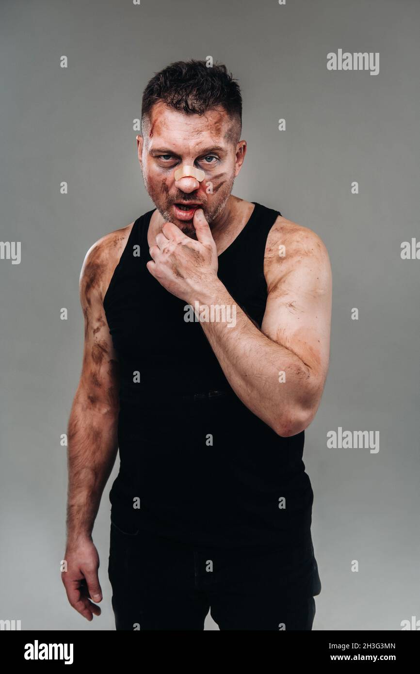 a battered man in a black T shirt who looks like a drug addict and a ...