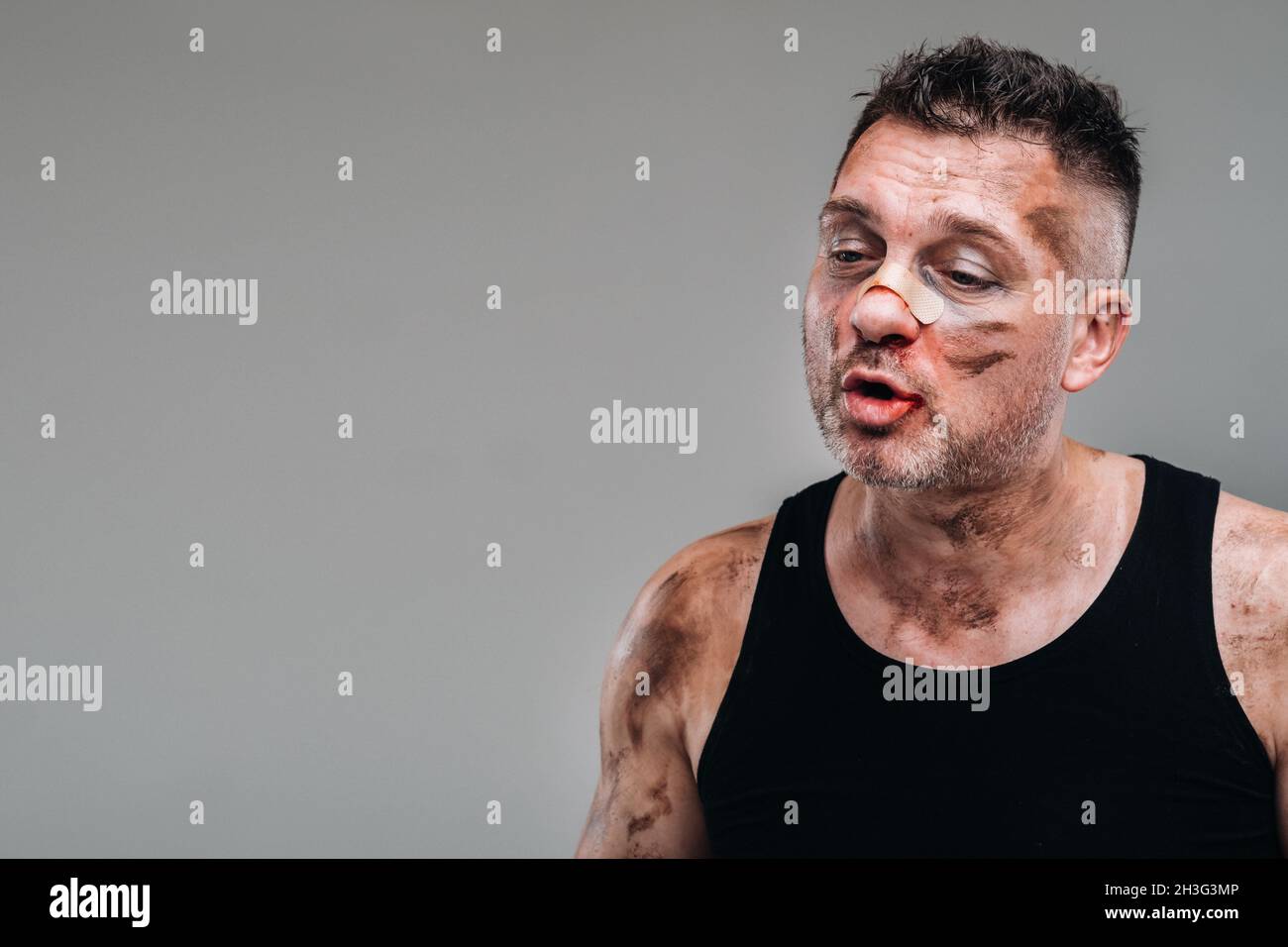 a battered man in a black T shirt who looks like a drug addict and a ...