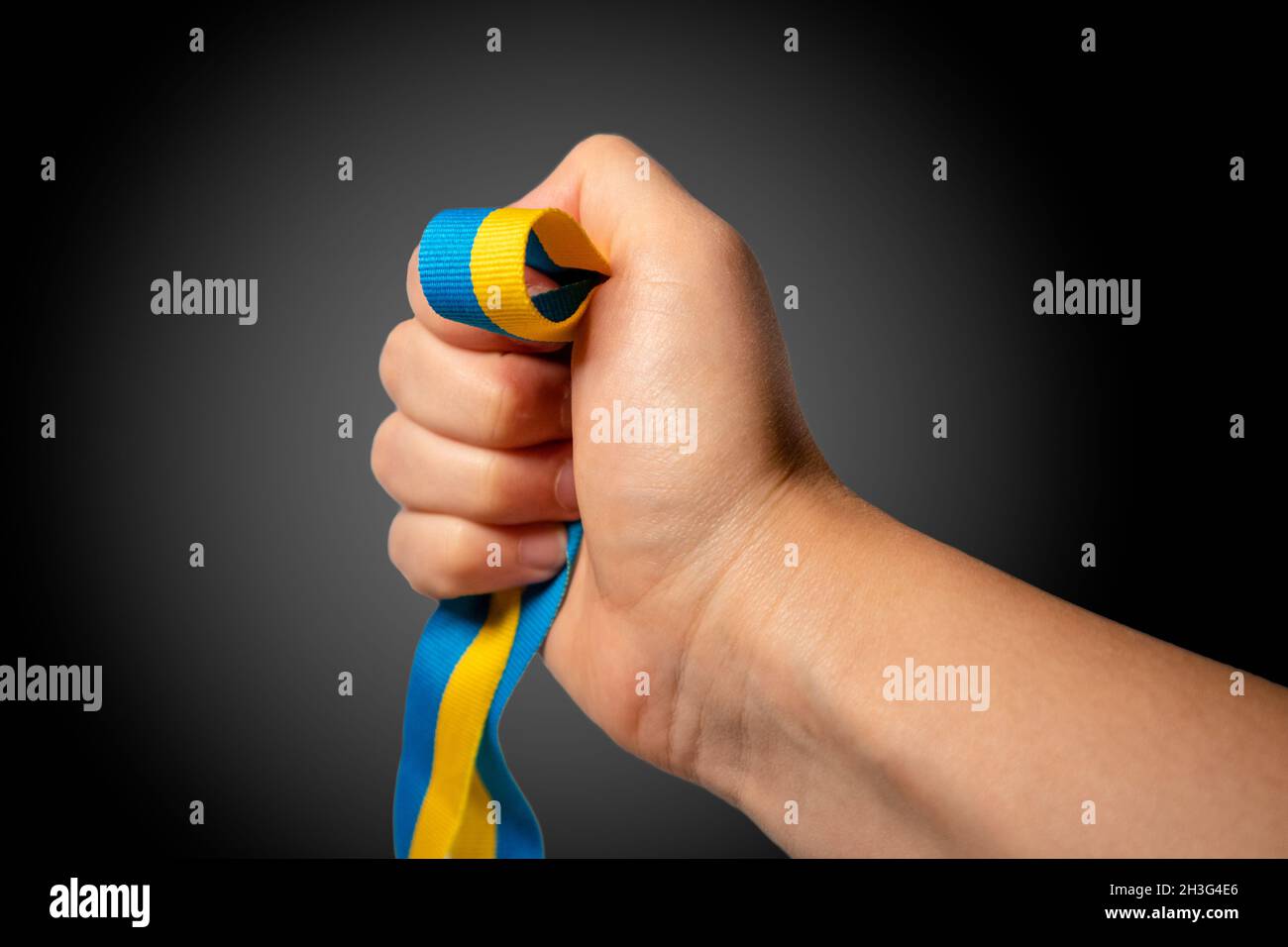 Woman hand holding yellow and blue, Ukrainian national flag colors ...