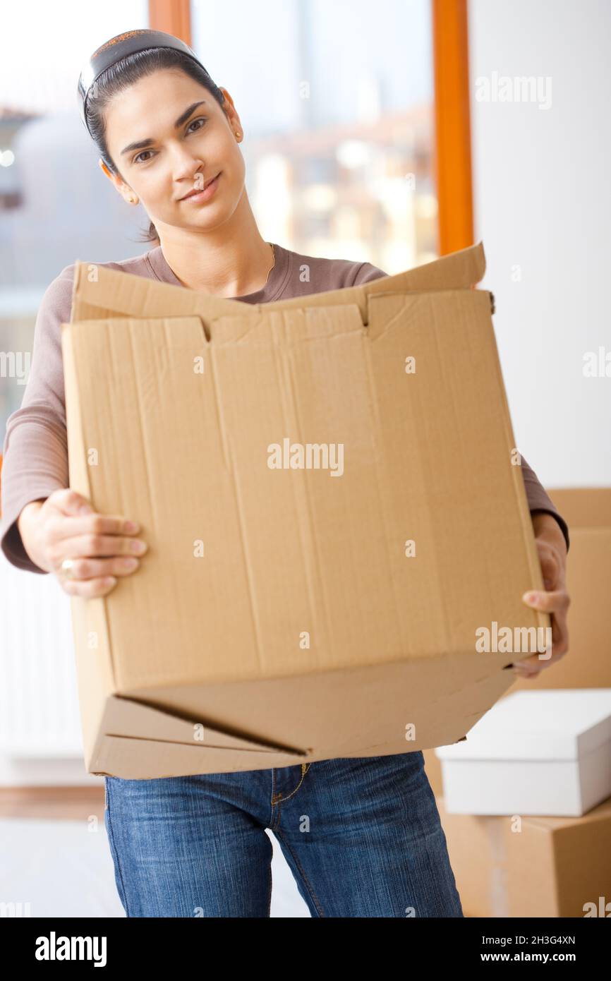 Young woman lifting cardboard box Stock Photo - Alamy