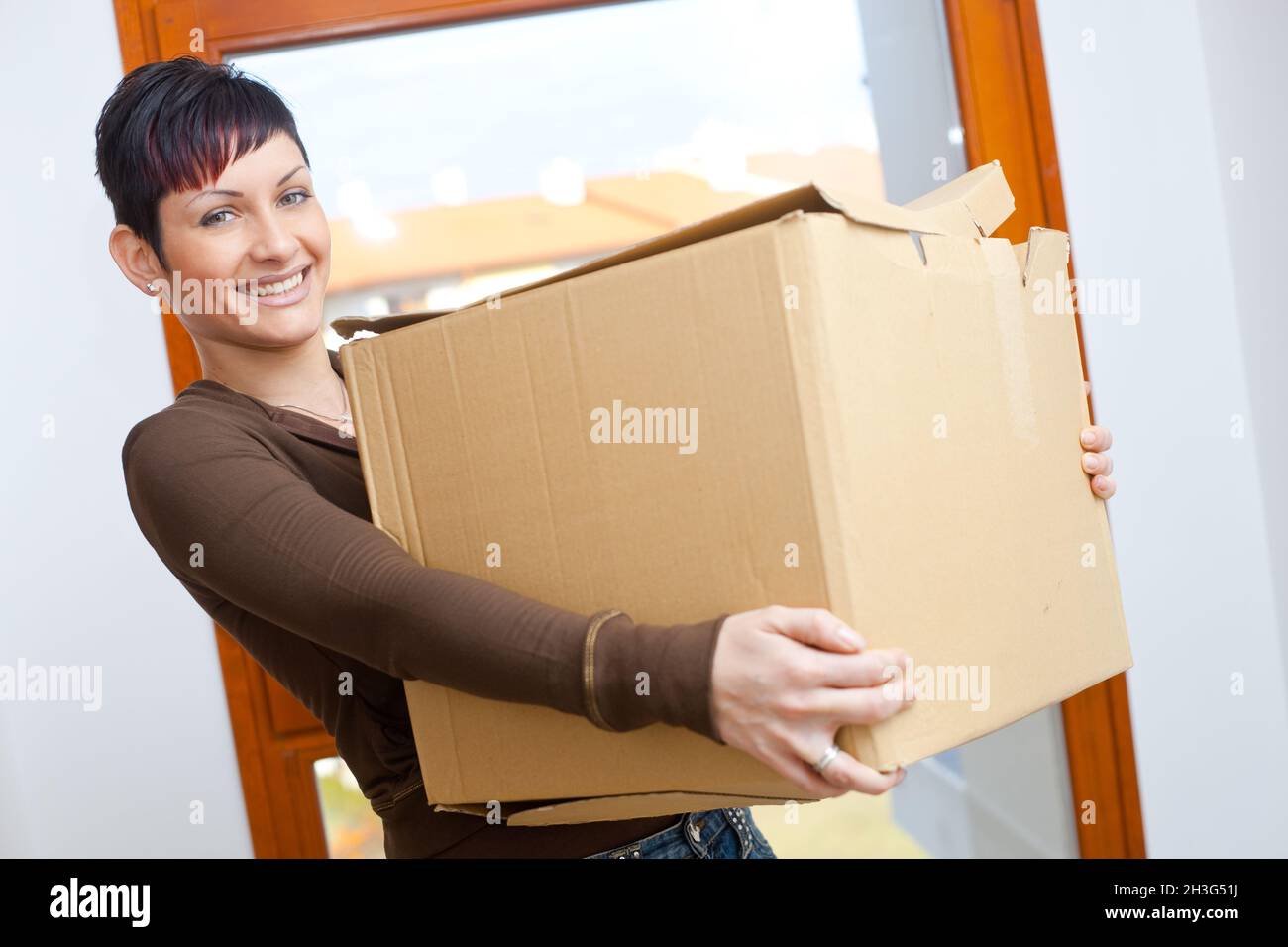 Young woman lifting cardboard box Stock Photo - Alamy