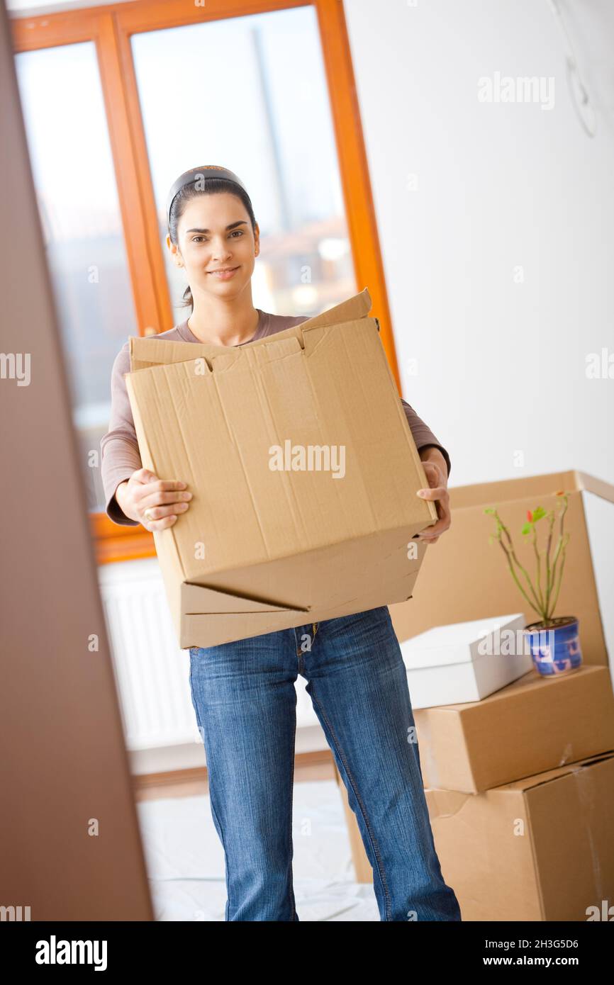 Young woman lifting cardboard box Stock Photo - Alamy