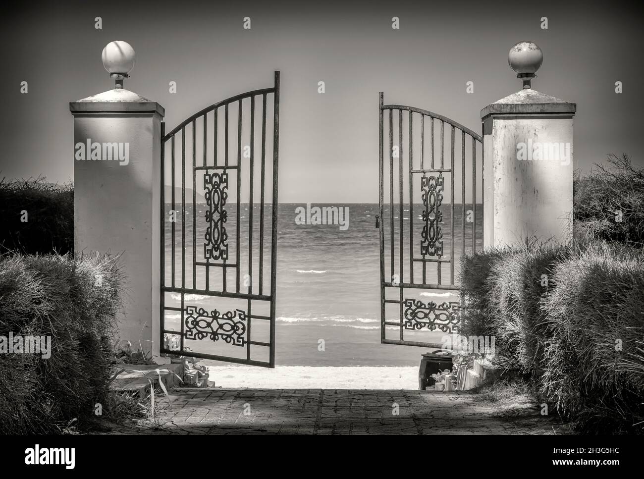 A lattice gate with sccess to the sea black and white Stock Photo - Alamy