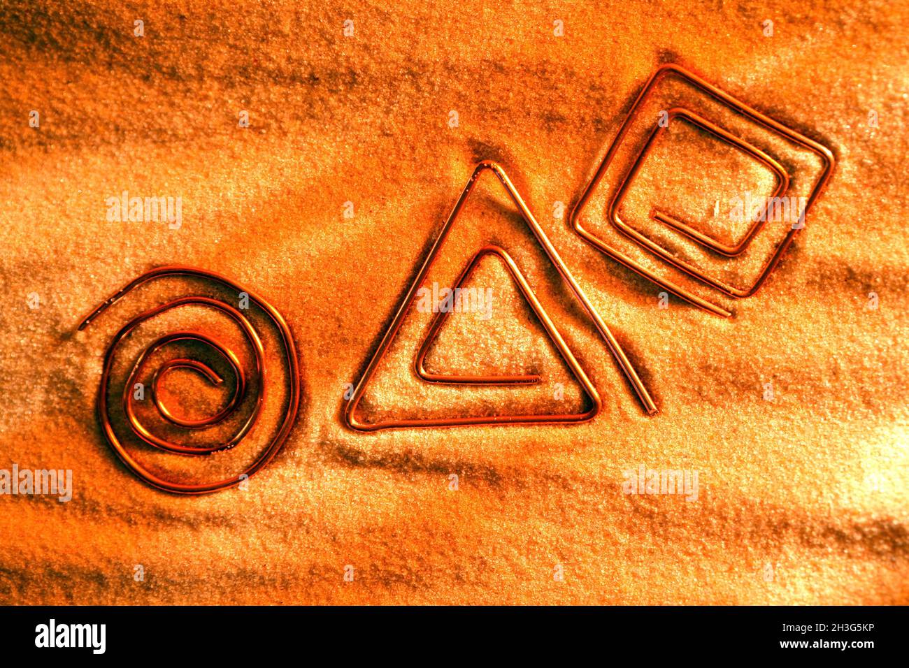 Abstract symbols made from copper wire on sand surface Stock Photo - Alamy