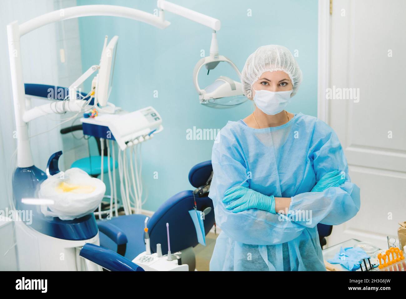 a female dentist wearing a medical mask and rubber gloves poses for the ...