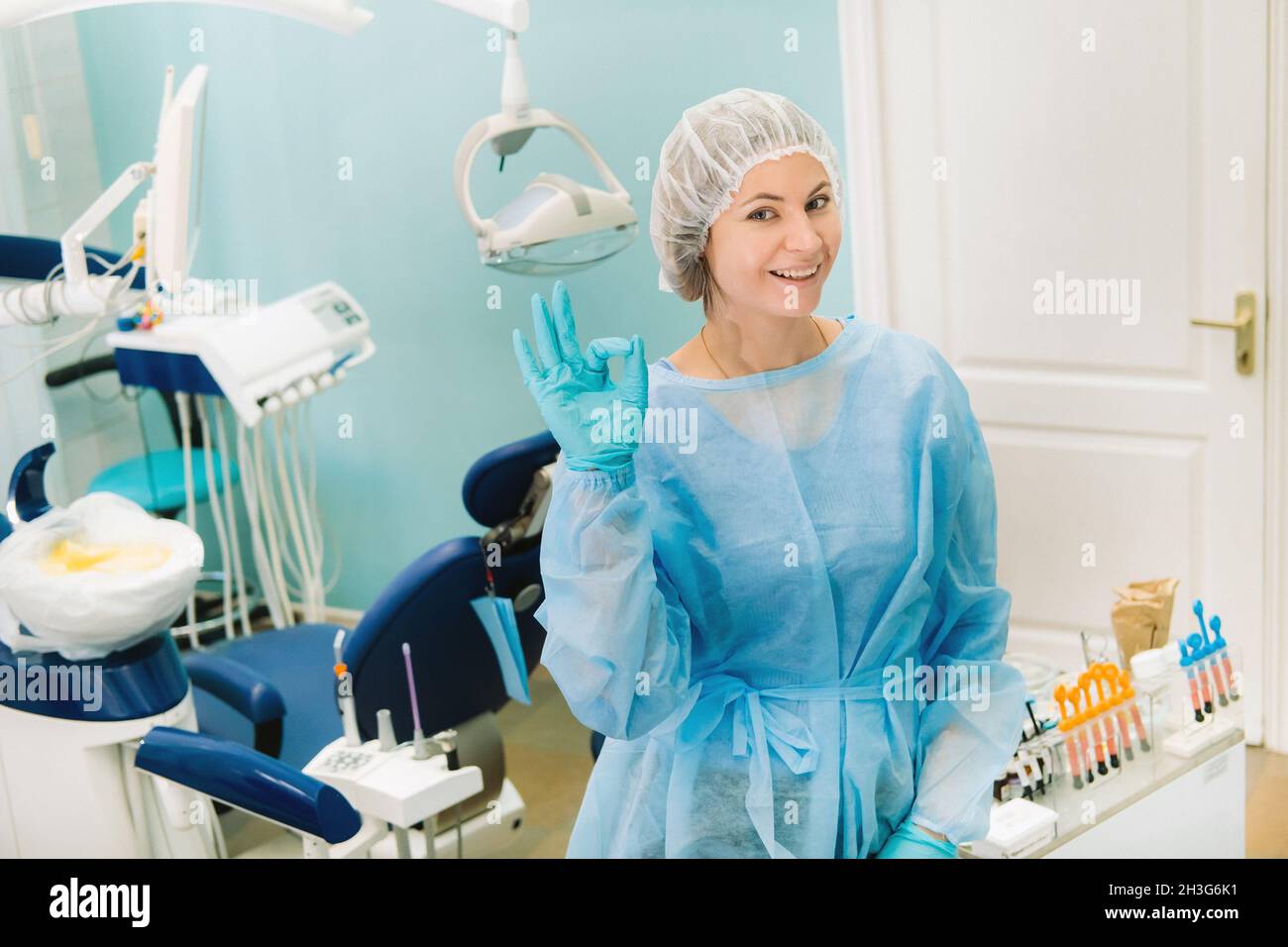the dentist stands in his office and shows the OK sign Stock Photo - Alamy