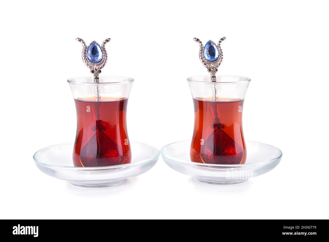 Traditional turkish tea in two glasses with spoons on white background ...