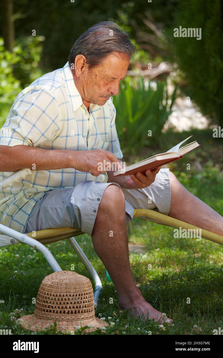 Aged man reading book Stock Photo - Alamy