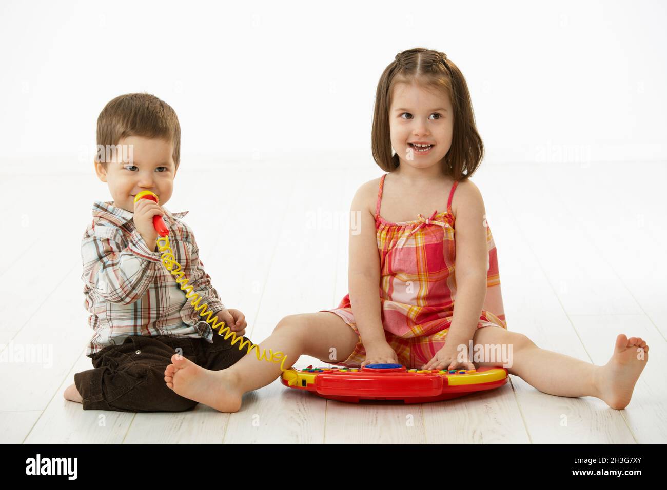 Little children playing with toy instrument Stock Photo - Alamy