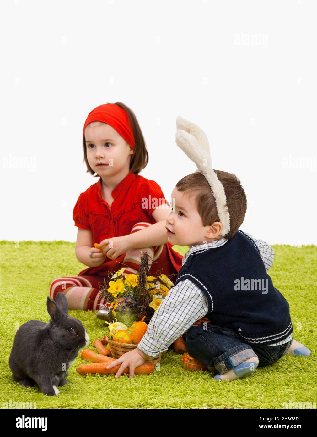Little children playing with Easter bunny Stock Photo - Alamy