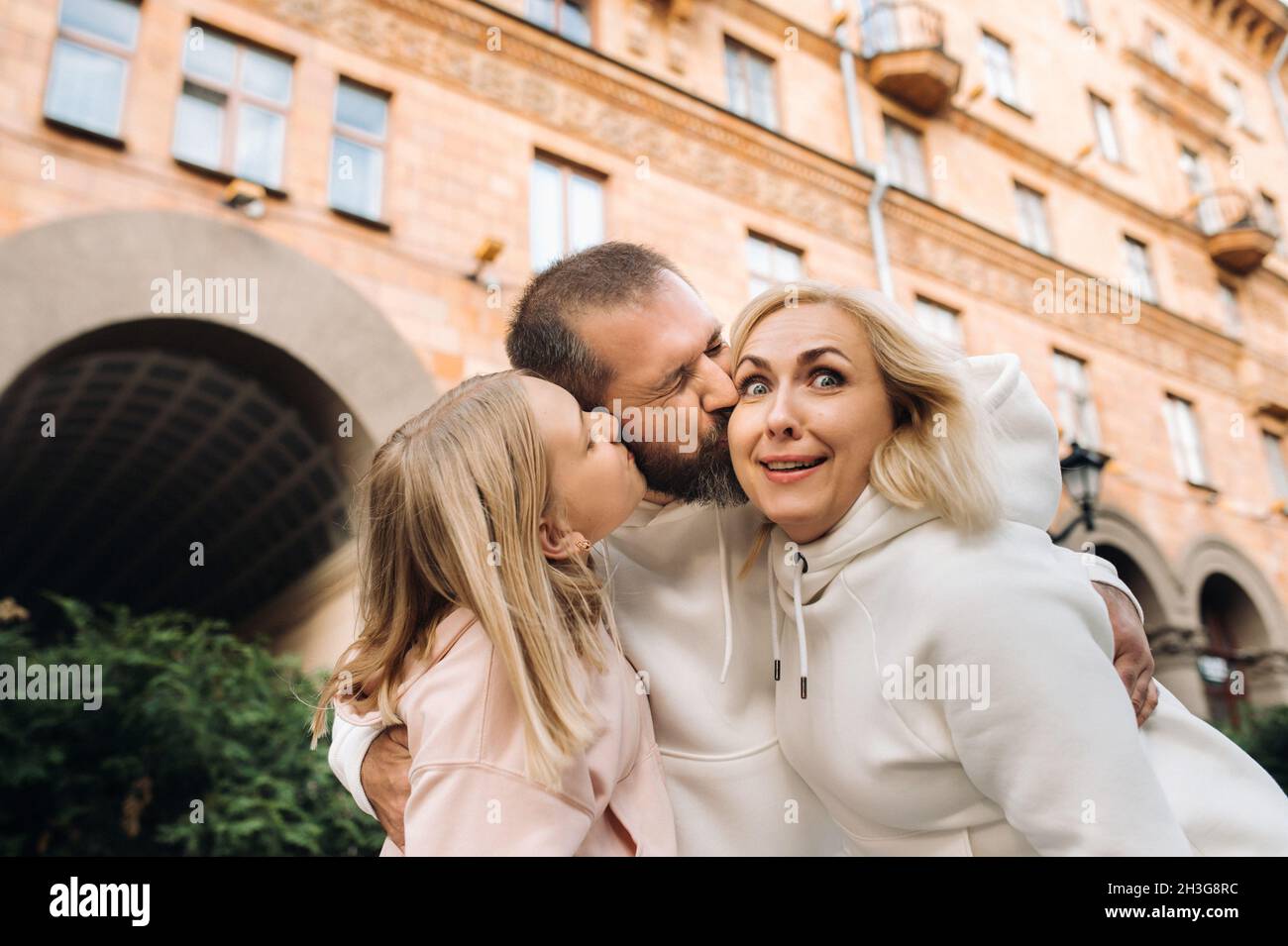 A happy family in white clothes walks around the city.A fun walk Stock ...