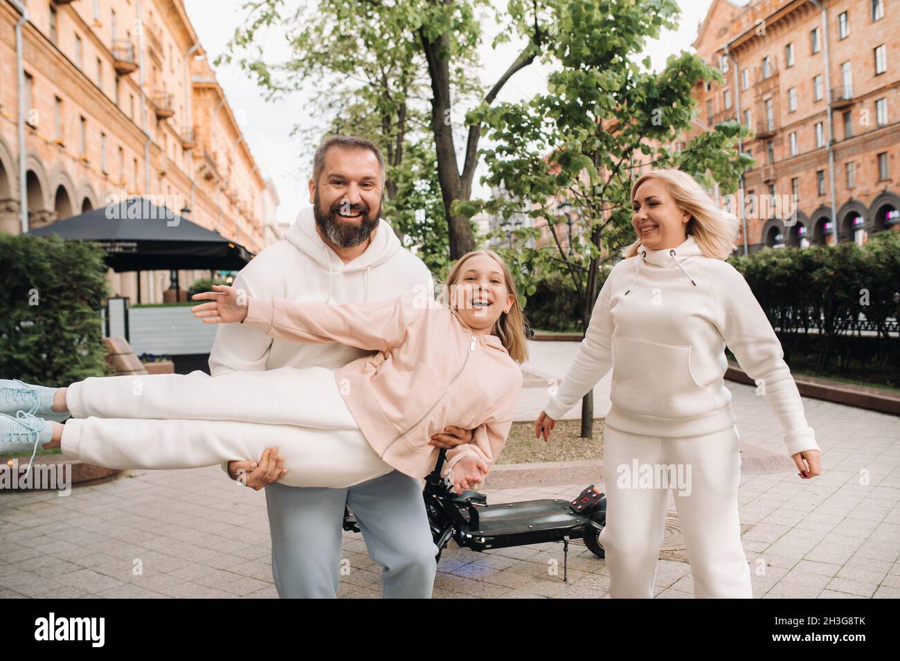 A happy family in white clothes walks around the city.A fun walk Stock ...