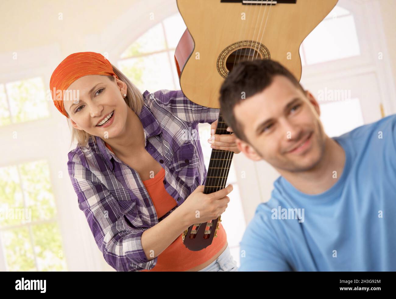Woman playing joke of guitar attack Stock Photo - Alamy