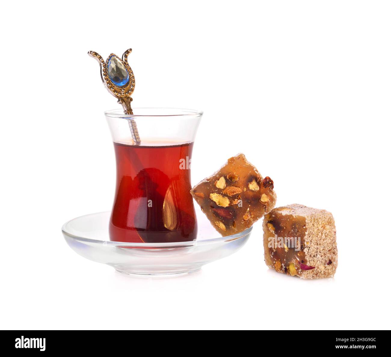 Traditional turkish delight rahat lokum with glass of tea on a white ...