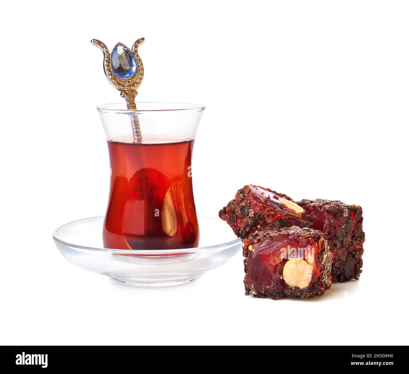 Traditional turkish delight rahat lokum with glass of tea on a white ...