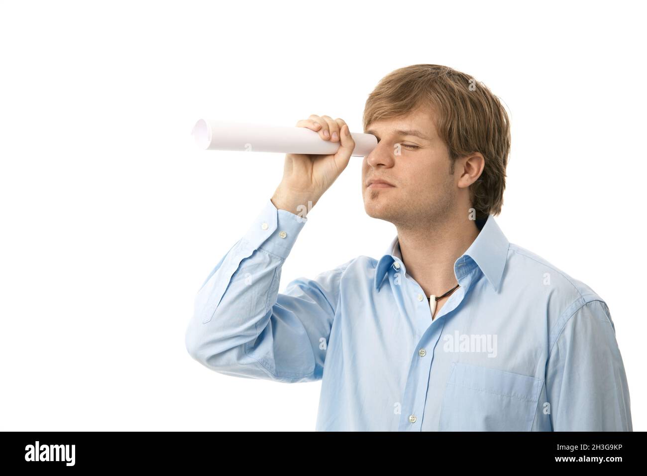 Young man looking through paper Stock Photo - Alamy