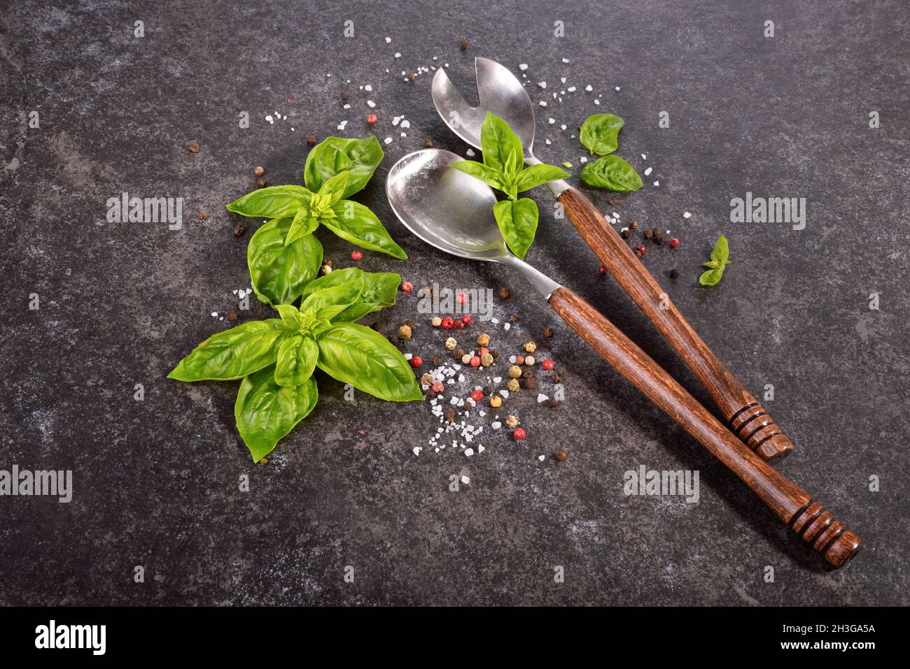 Top view of vintage spoons laying on the stone desk with salt, pepper ...