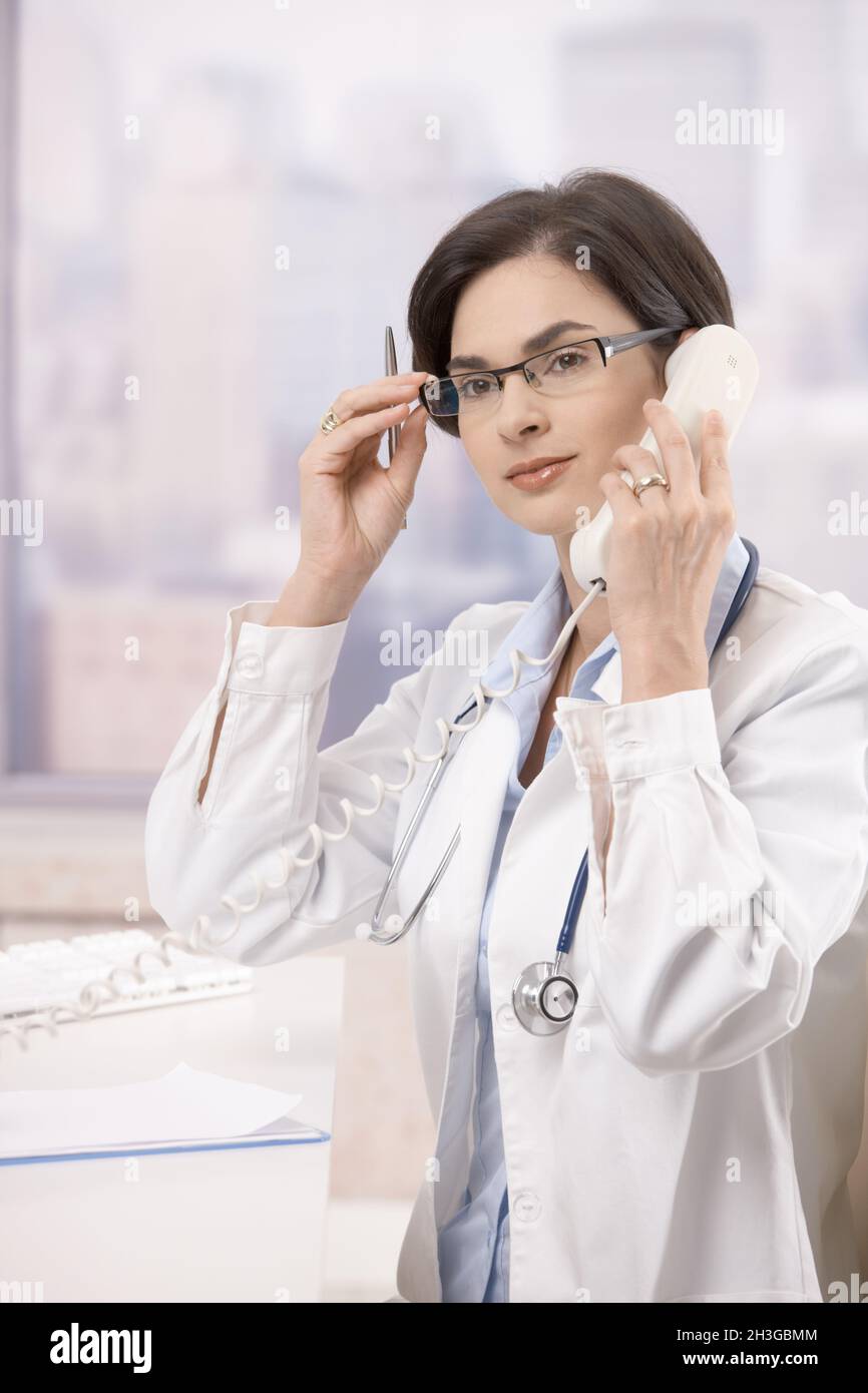 Young doctor answering phone call Stock Photo - Alamy