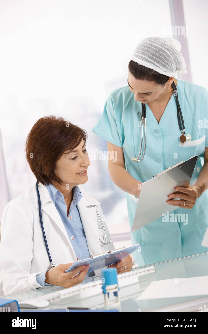 Nurse and senior doctor analysing diagnosis Stock Photo - Alamy