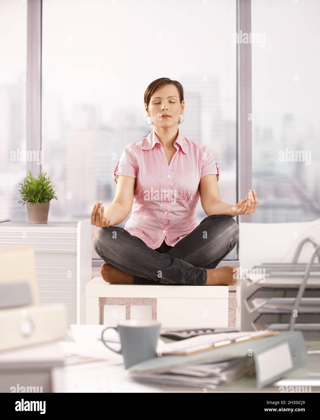 Office worker meditating Stock Photo - Alamy
