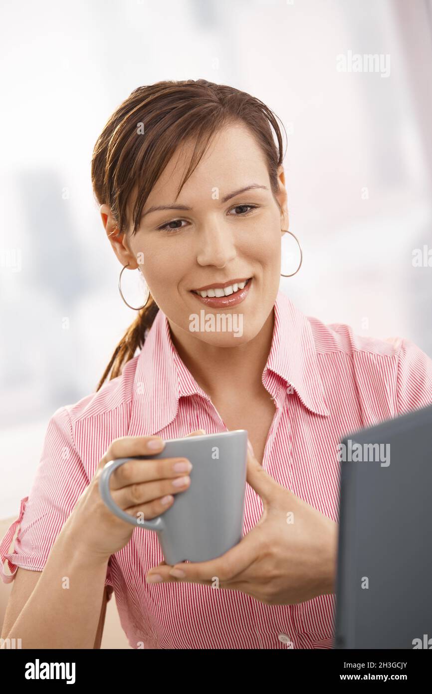 Office worker drinking tea at desk Stock Photo - Alamy