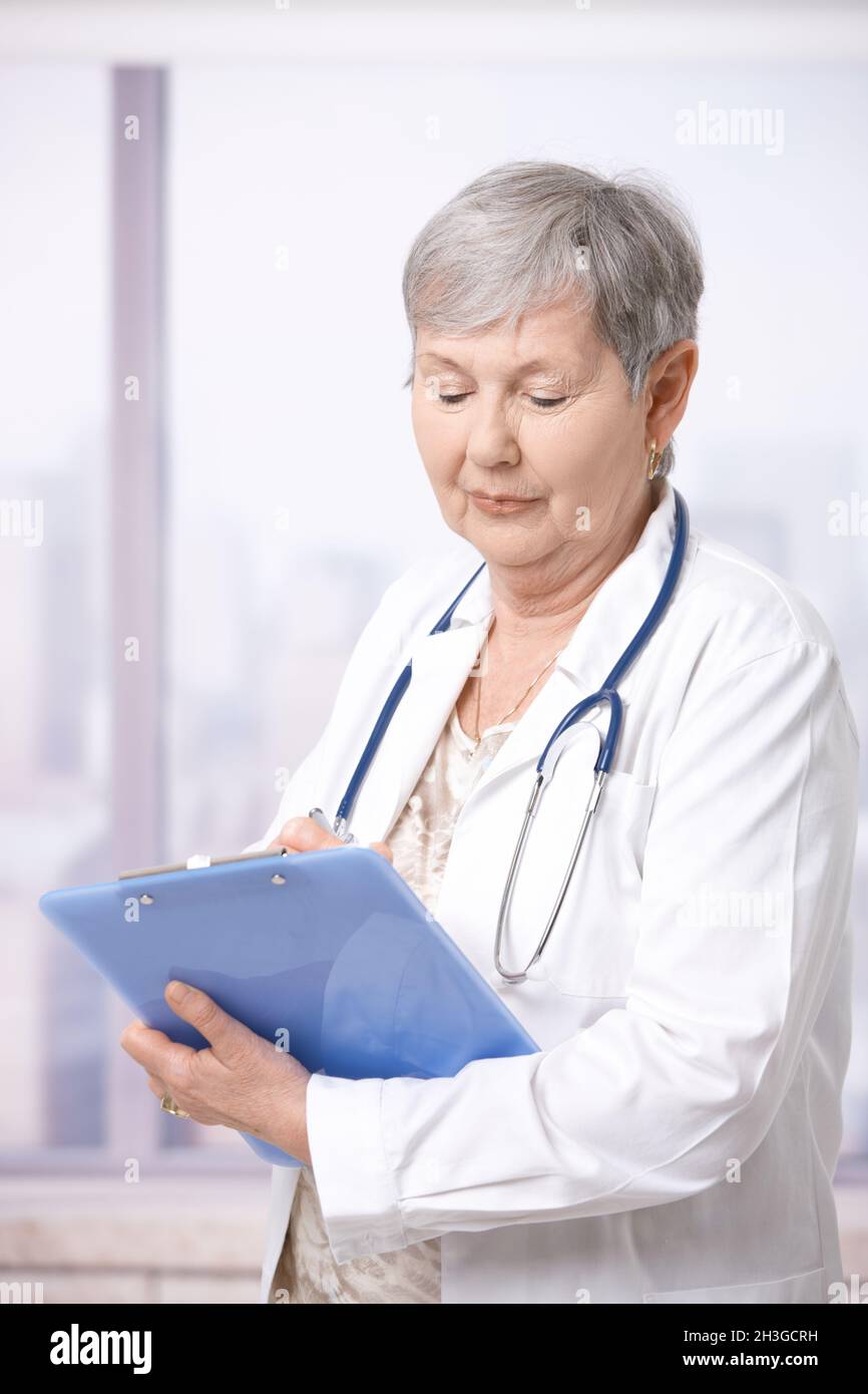 Senior doctor taking notes Stock Photo - Alamy