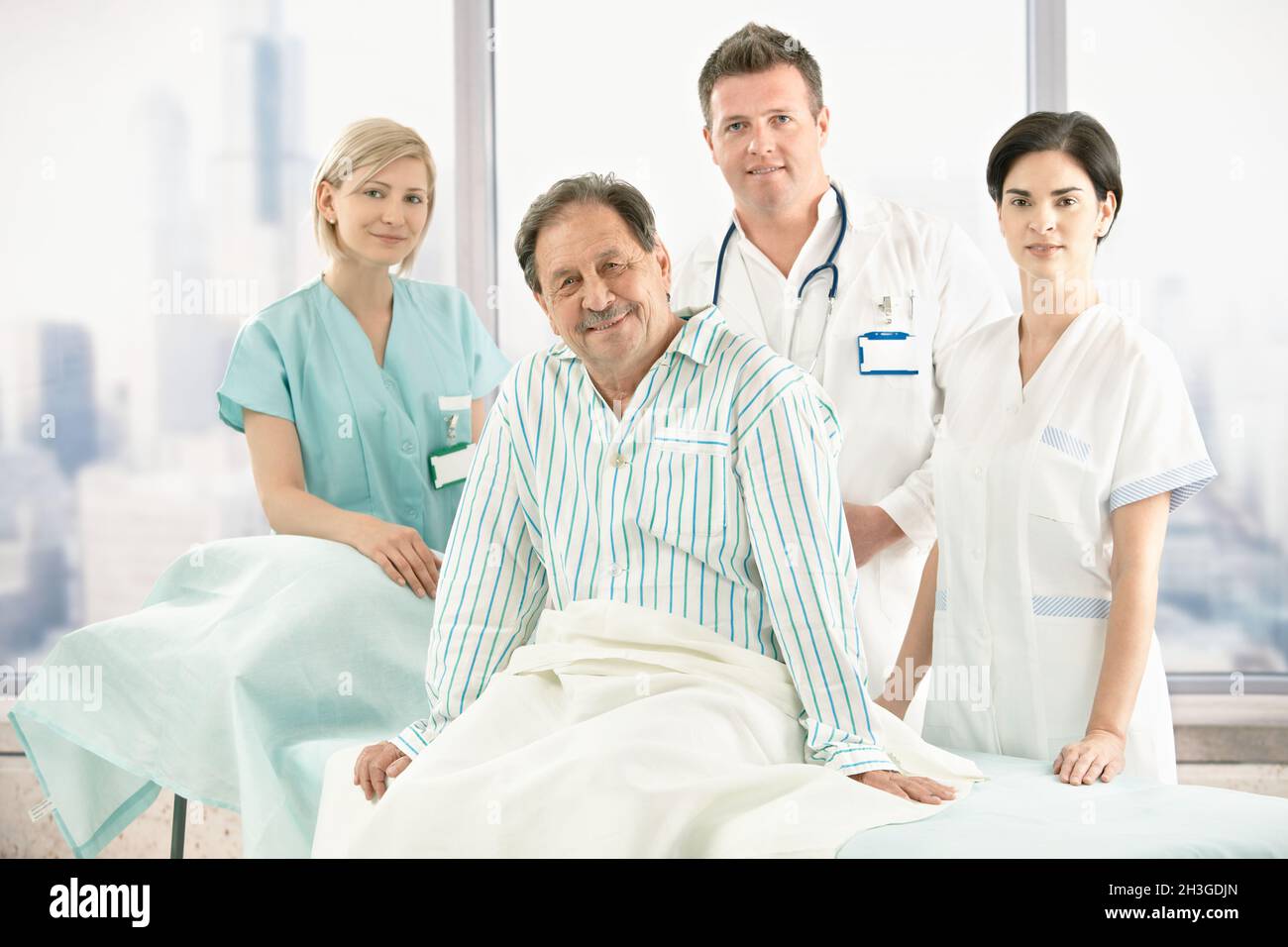 Older patient on bed with hospital crew Stock Photo - Alamy