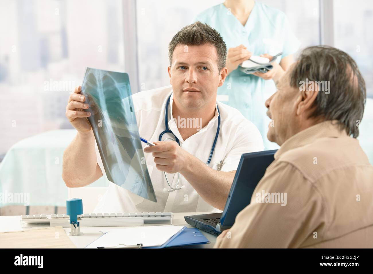 Doctor showing x-ray image to patient Stock Photo - Alamy