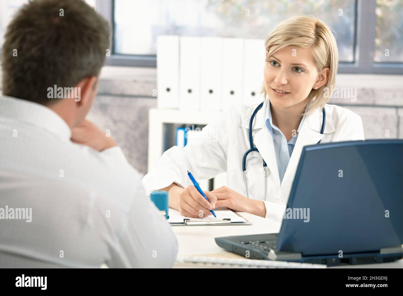 Doctor taking notes about patient Stock Photo - Alamy