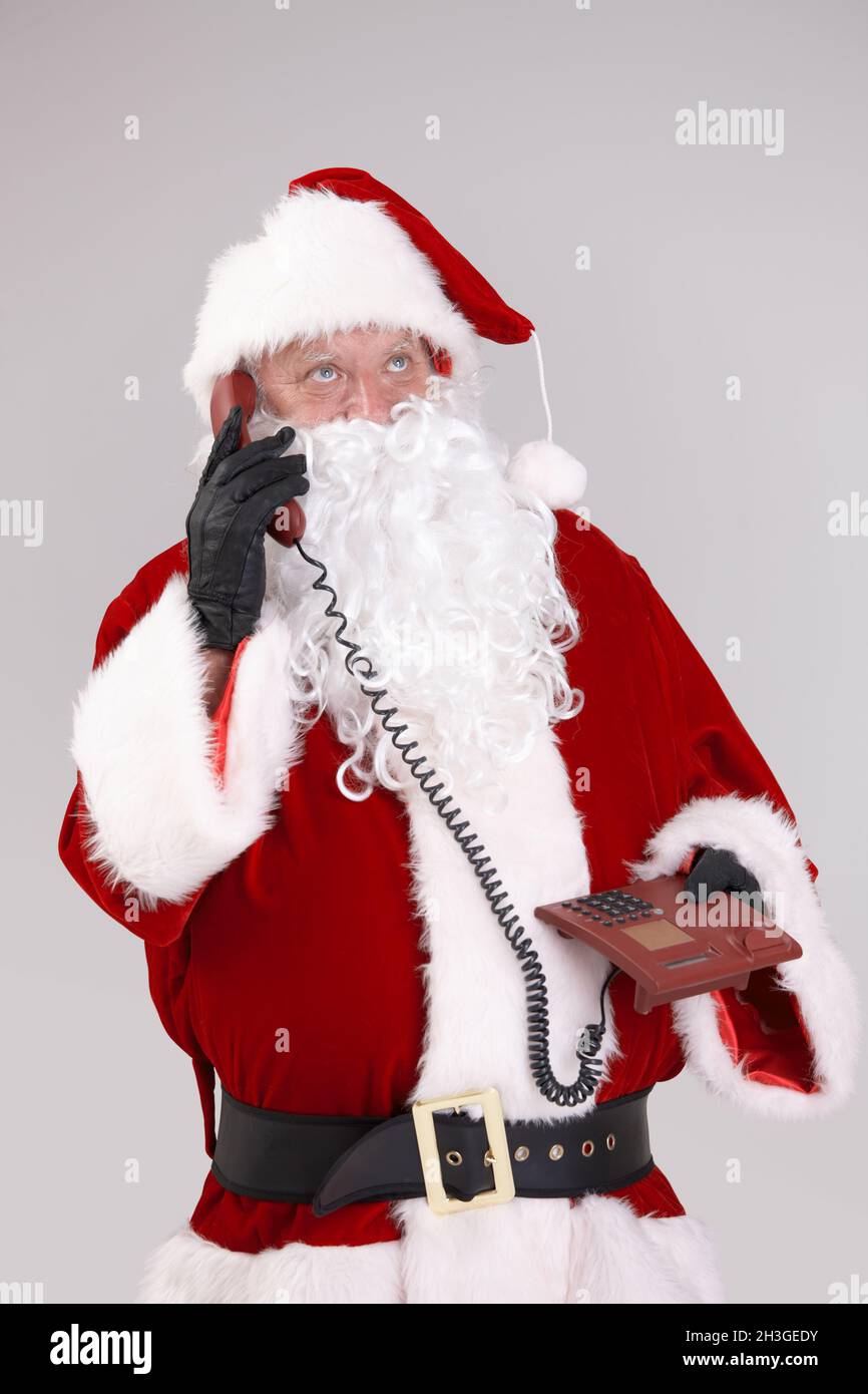 Santa on the phone looking up Stock Photo - Alamy