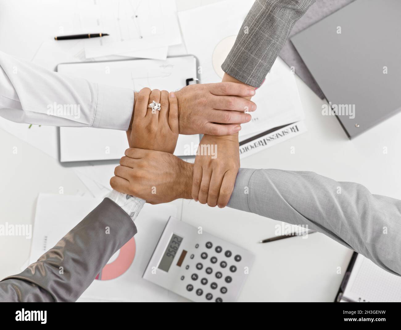 Four hands together in unity at businessmeeting Stock Photo - Alamy
