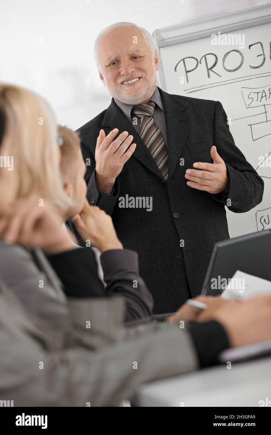 Senior executive explaining work to colleagues Stock Photo - Alamy