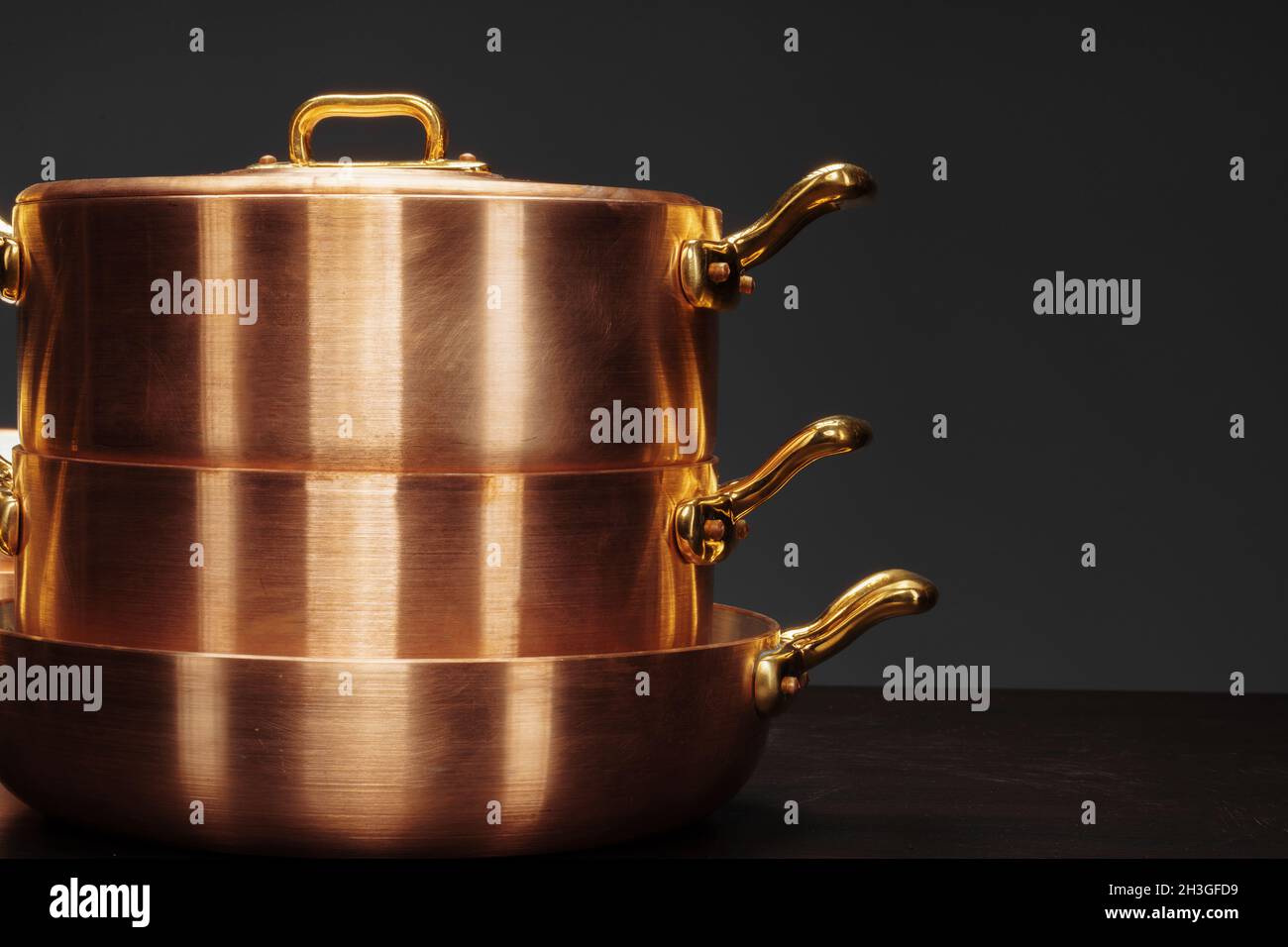 Shiny vintage copper cookware over dark background Stock Photo - Alamy