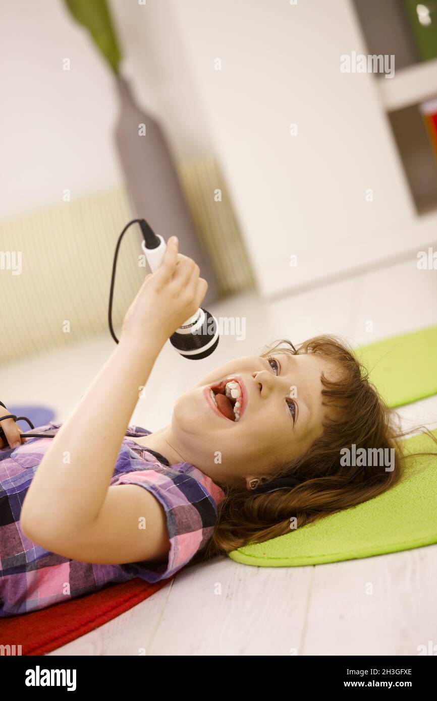 Young girl singing into microphone Stock Photo - Alamy