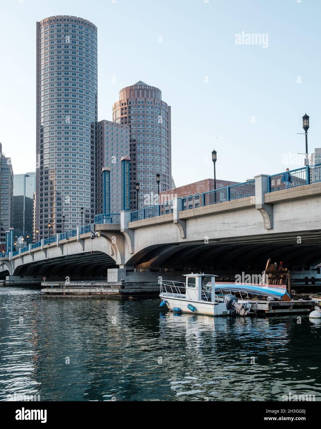 Modern round buildings and a stone bridge over the lake water with an ...