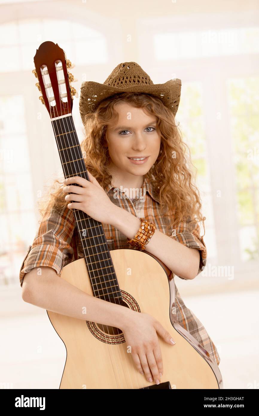 Pretty young woman hugging guitar Stock Photo - Alamy