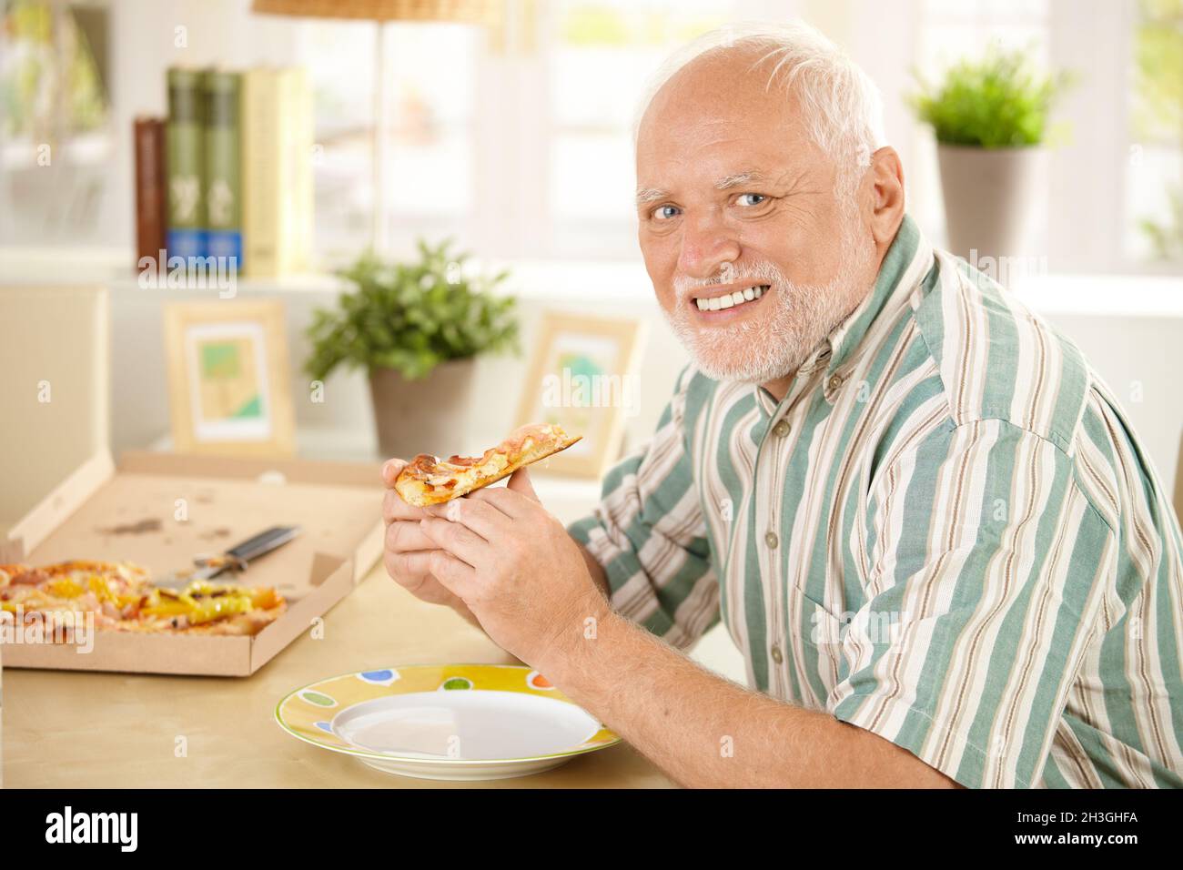 Portrait of senior having pizza Stock Photo - Alamy