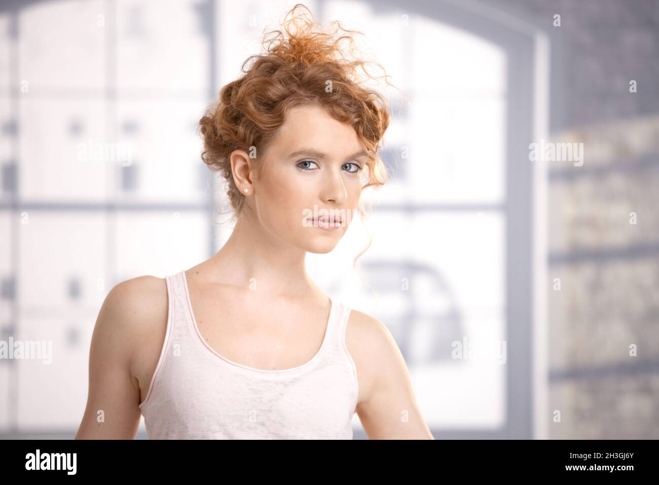 Pretty girl standing front of window Stock Photo - Alamy