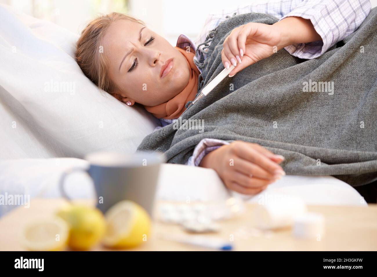 Young female having flu laying in bed Stock Photo - Alamy