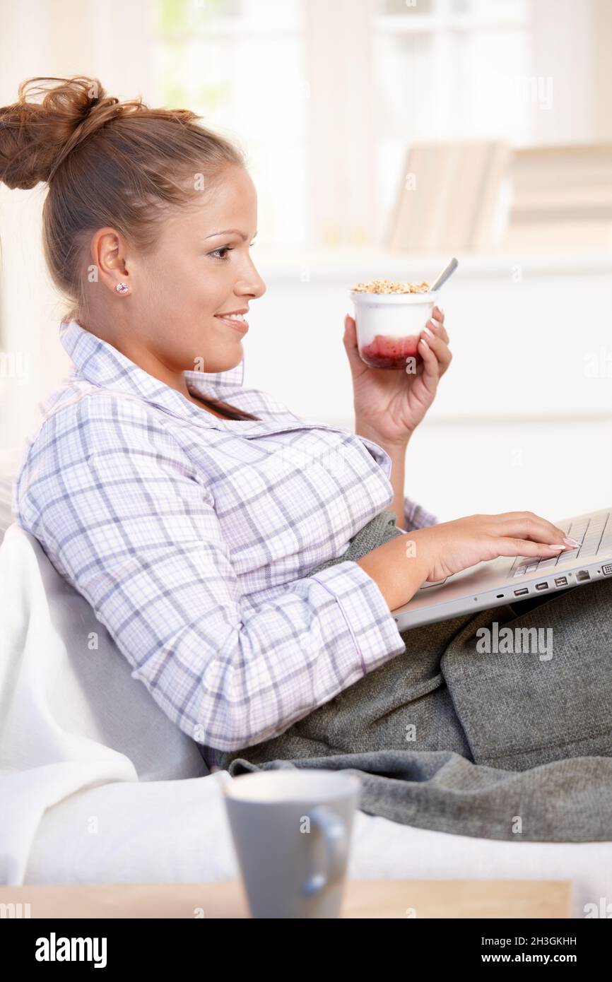 Pretty girl browsing Internet in bed smiling Stock Photo - Alamy