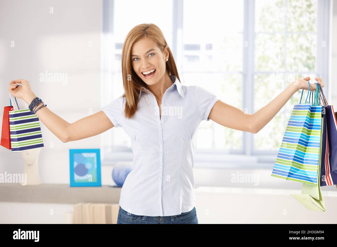 Happy woman arms wide open holding shopping bags Stock Photo - Alamy