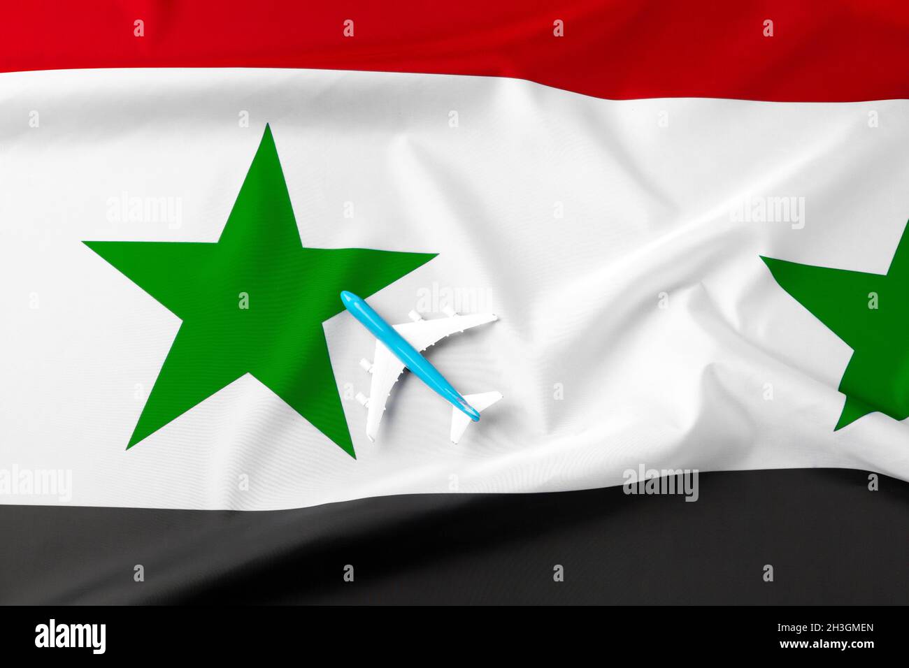 Small toy plane over the fabric flag of Syria Stock Photo - Alamy