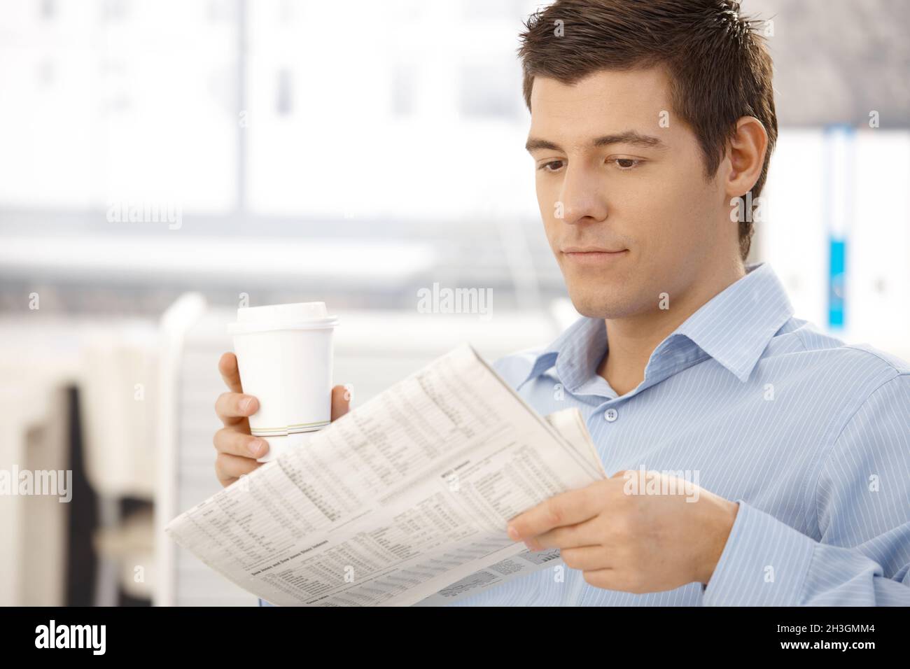 Office worker on break reading papers with coffee Stock Photo - Alamy