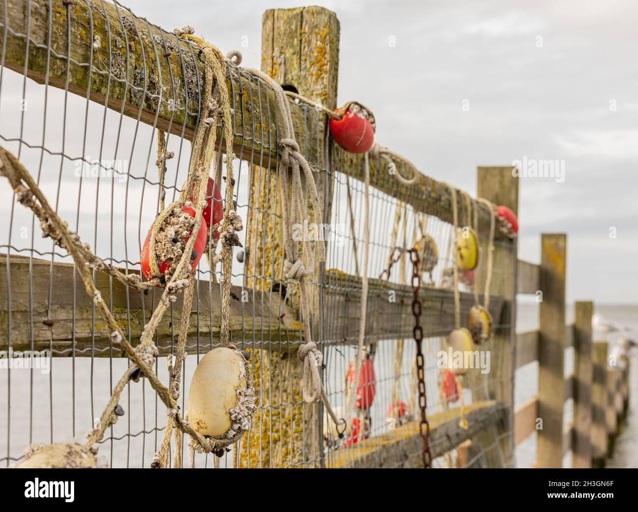 Fishing net with red floats hanging on a fence waiting for better ...
