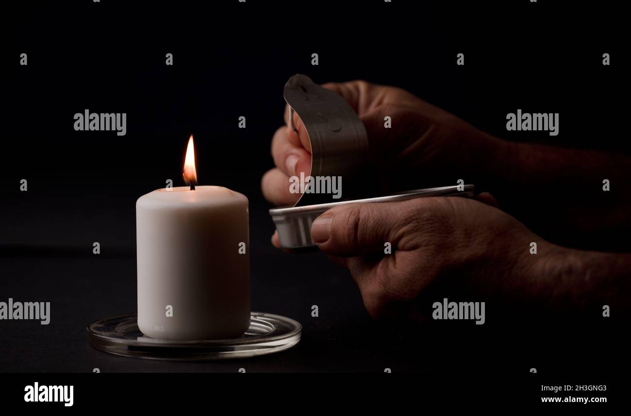 concept of energy blackout, lit candle, with can of preserves in man's ...