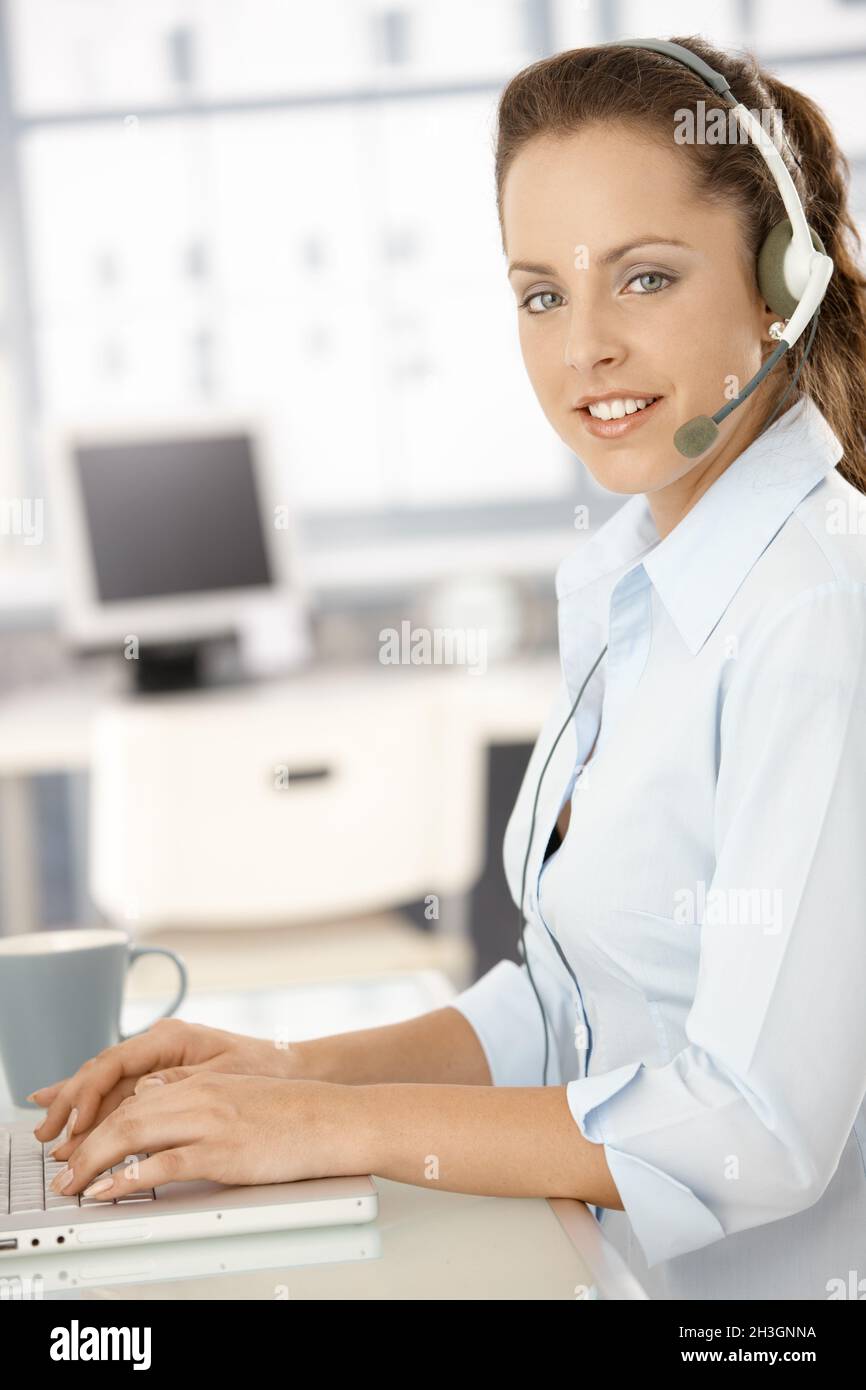 Pretty dispatcher working in bright office smiling Stock Photo - Alamy