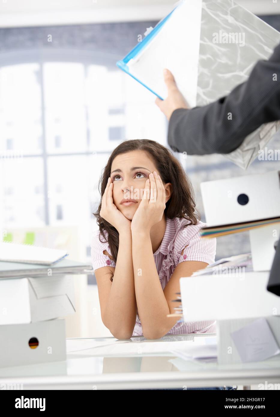 Young office worker having too much work Stock Photo - Alamy