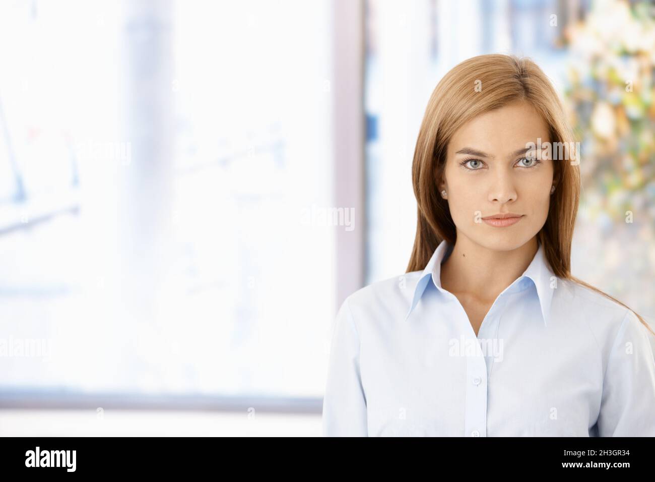 Portrait of attractive woman front of window Stock Photo - Alamy