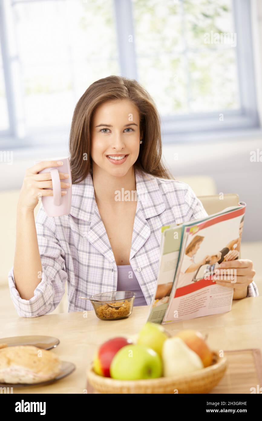Happy woman at breakfast with magazine Stock Photo - Alamy