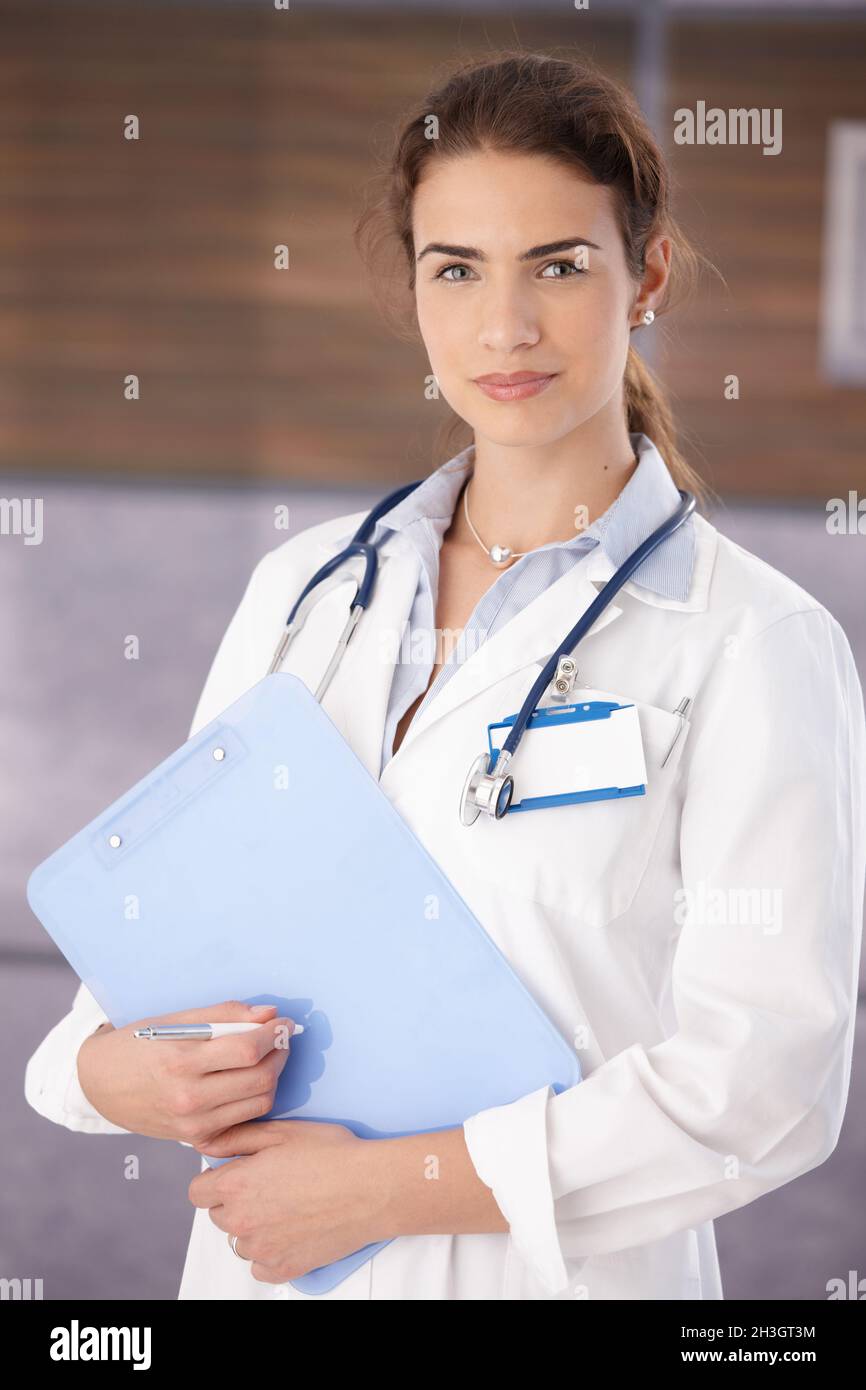 Attractive female doctor holding papers Stock Photo - Alamy